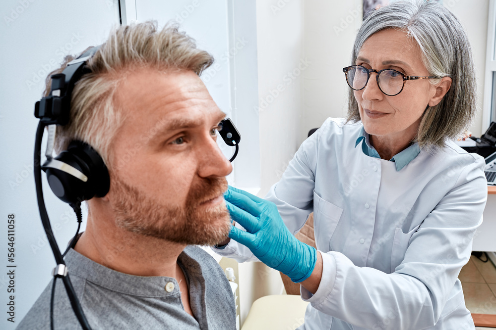 Mature man receives tympanometry with audiologist using tympanometer at ...