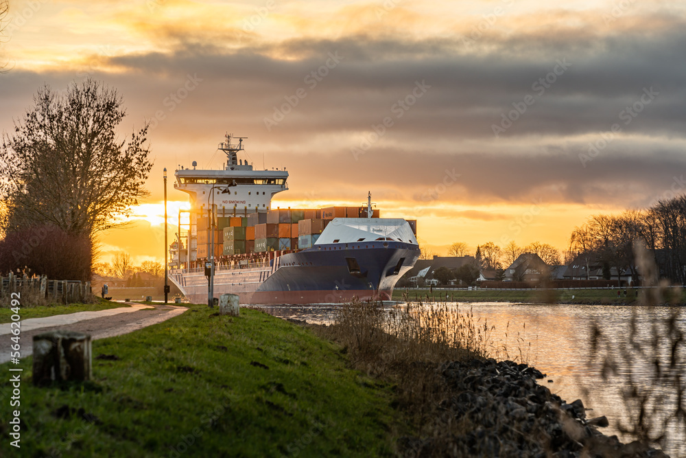 Nord Ostsee Kanal, Durchfahrt Containerschiff. Sonnenuntergang am Kiel Kanal mit Schiff. Der ...