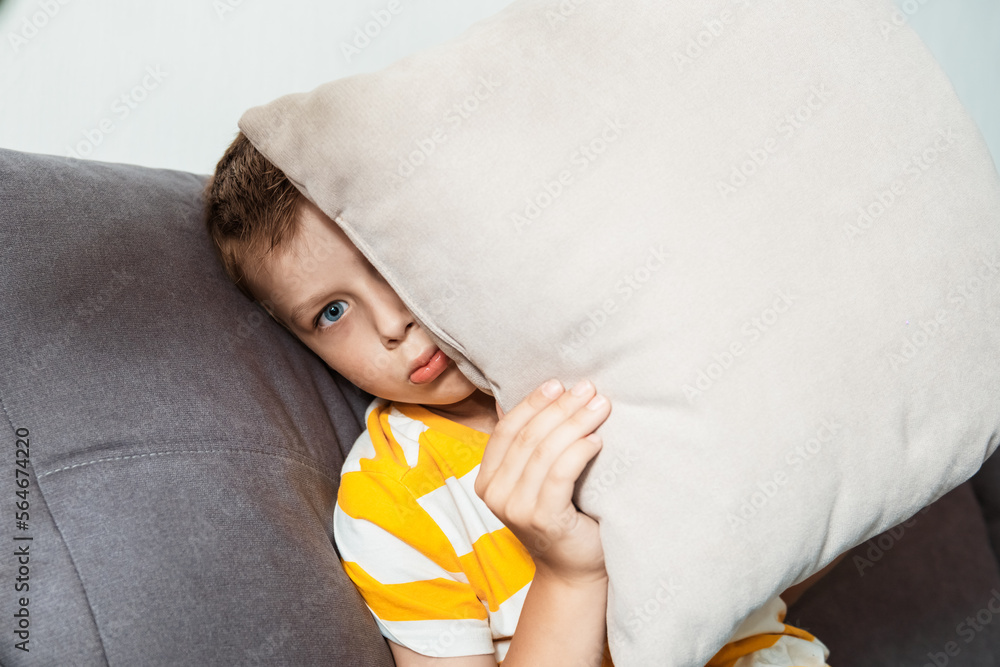 Upset little child boy crying sitting alone in fetal position hiding ...