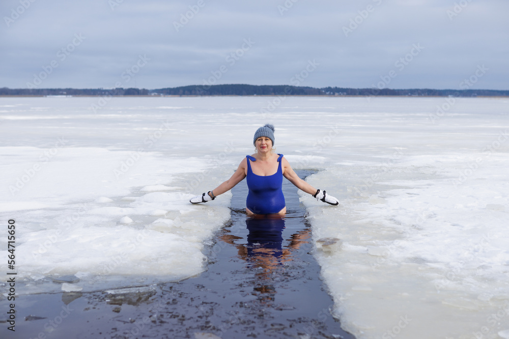 Winter swimming. Woman in frozen lake ice hole. Swimmers wellness and ...