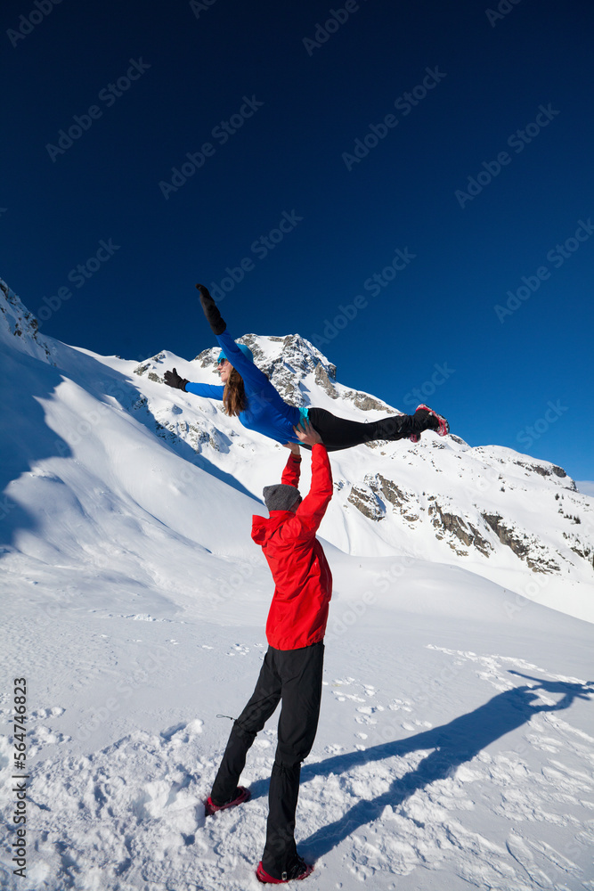 A fit young couple preform acrobatic yoga (bird pose) below Joffre Peak ...