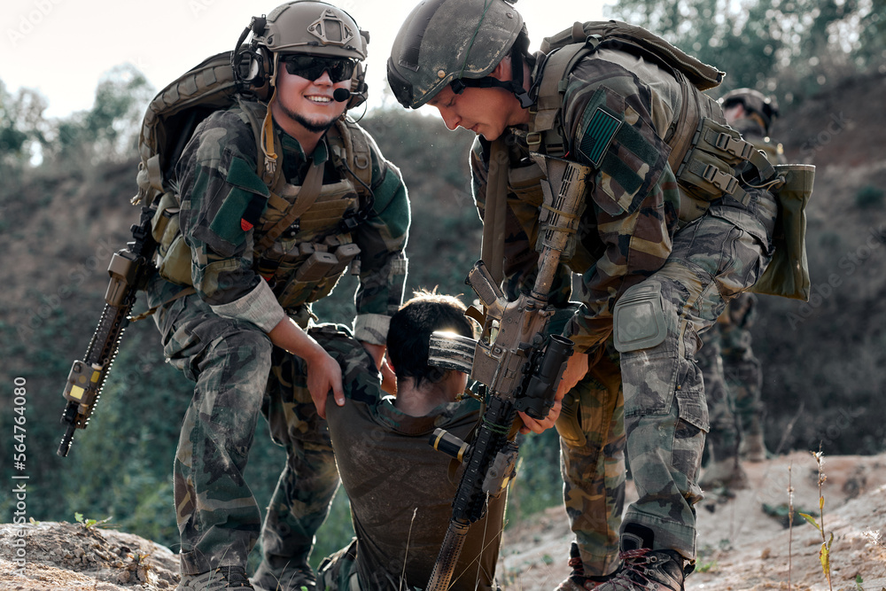 Foto de Soldiers rescue wounded soldier from battlefield.Military men ...