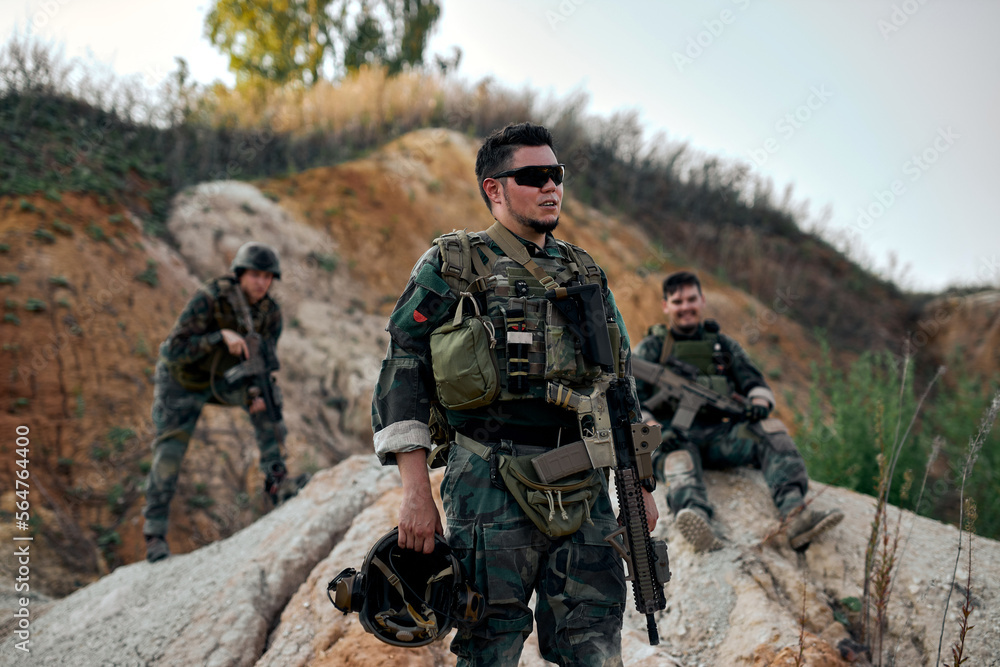 Team of army soldier with rifles in combat uniforms in mountains, group ...