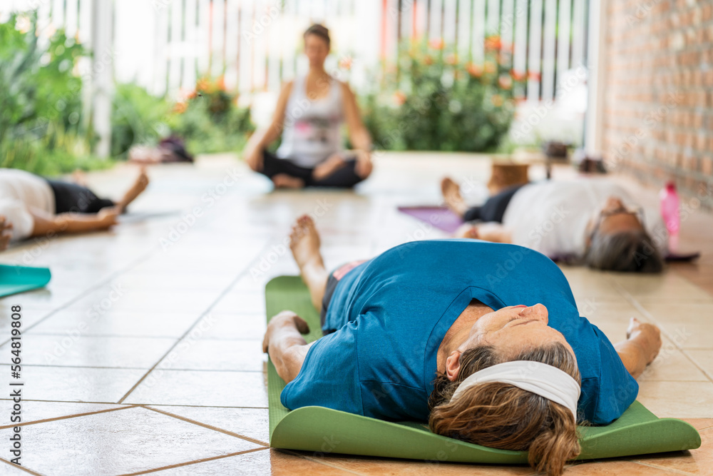 Relaxed yoga student lying on the ground on a yoga mat Stock Photo ...