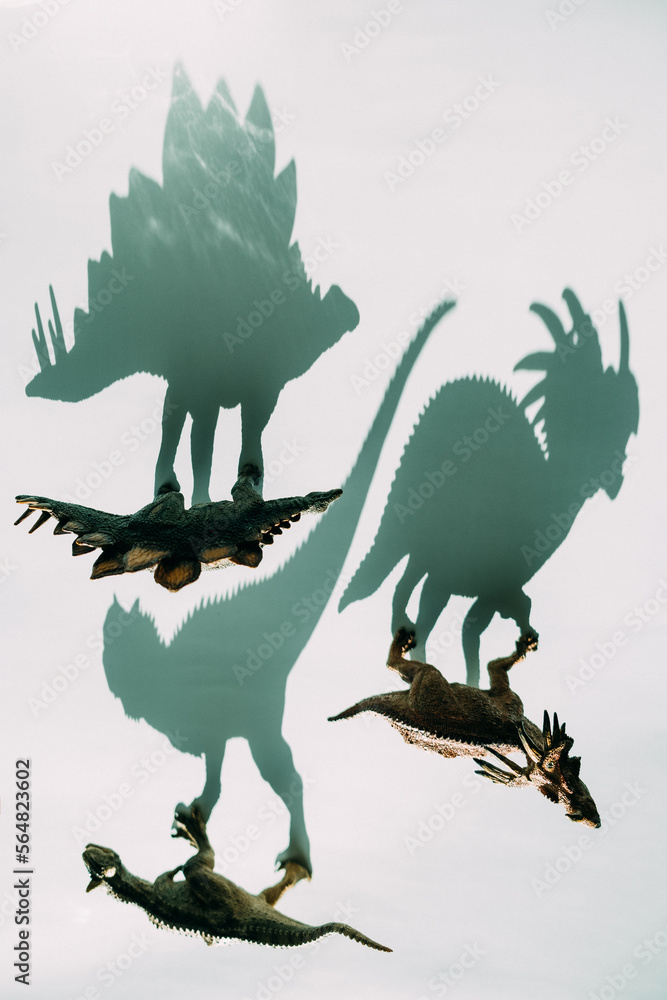 Toy figures of dinosaurs and their shadows. Stock Photo | Adobe Stock