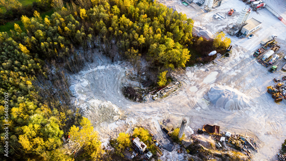 Damaging the environment. Concrete factory dump pit in forest. Aerial ...