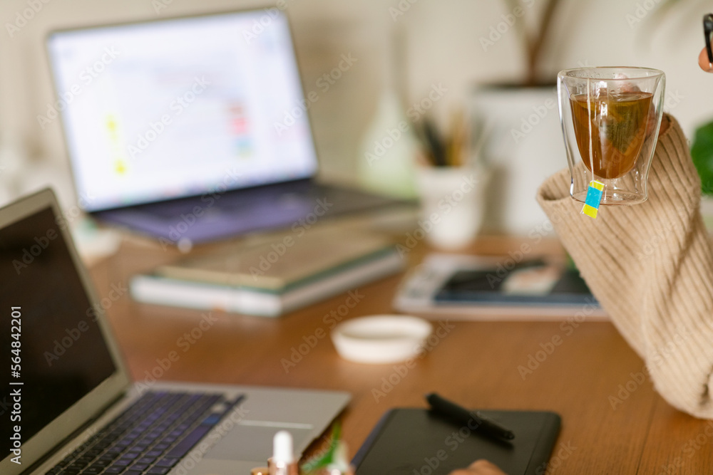 Anonymous woman having tea at cozy office desk Stock Photo | Adobe Stock
