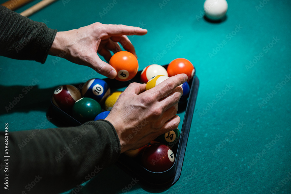 Crop man arranging balls in rack on billiard table Stock Photo | Adobe ...