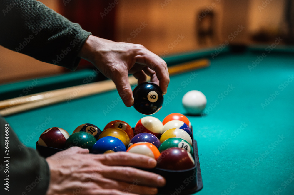 Crop man arranging balls in rack on billiard table Stock Photo | Adobe ...