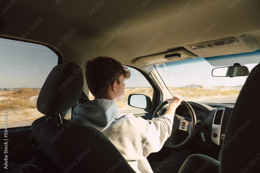Teenage boy driving a car Stock Photo | Adobe Stock