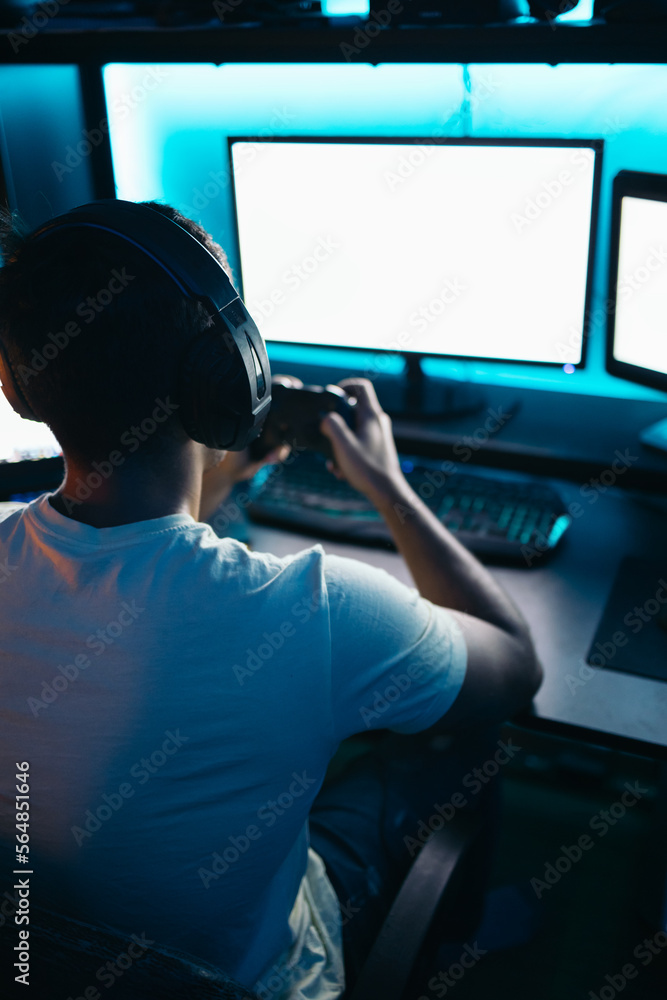 Gamer playing video games on multi-screen Stock Photo | Adobe Stock