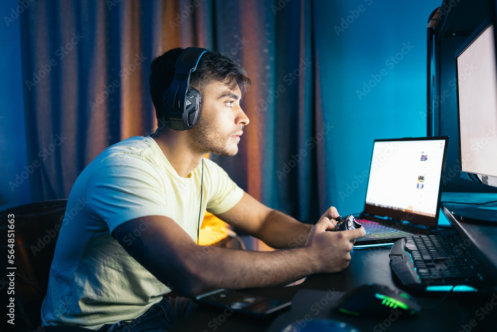 Gamer playing multi-screen video games online Stock Photo | Adobe Stock