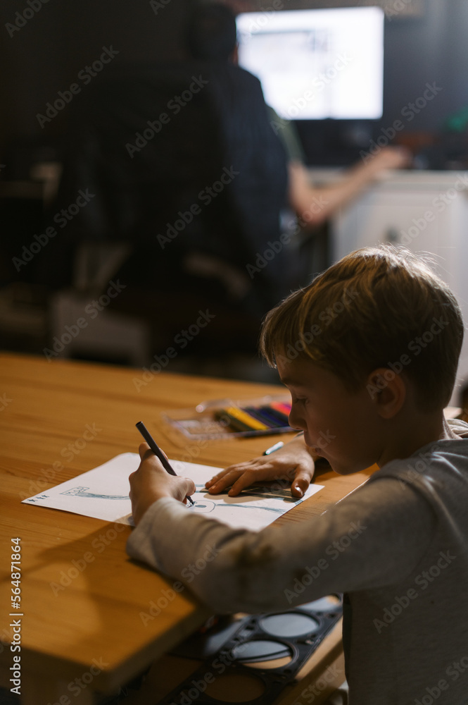 Little boy drawing while his dad works from home at the computer Stock ...