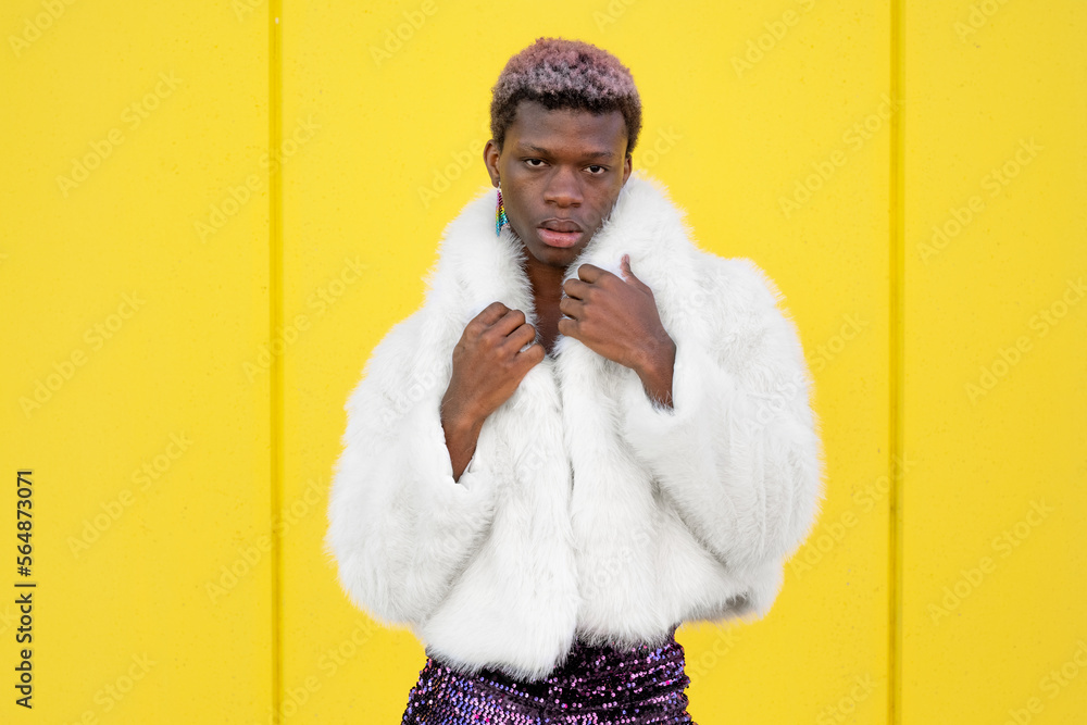 Transgender woman with sequined suit over yellow wall Stock Photo ...