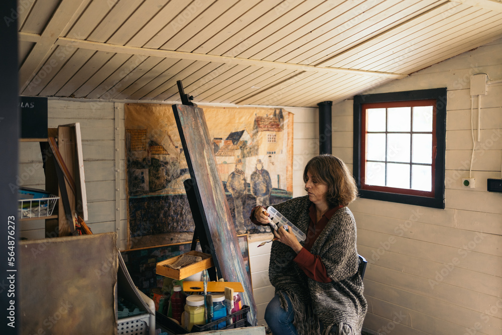 Mature woman artist painting in a small painting workshop Stock Photo ...