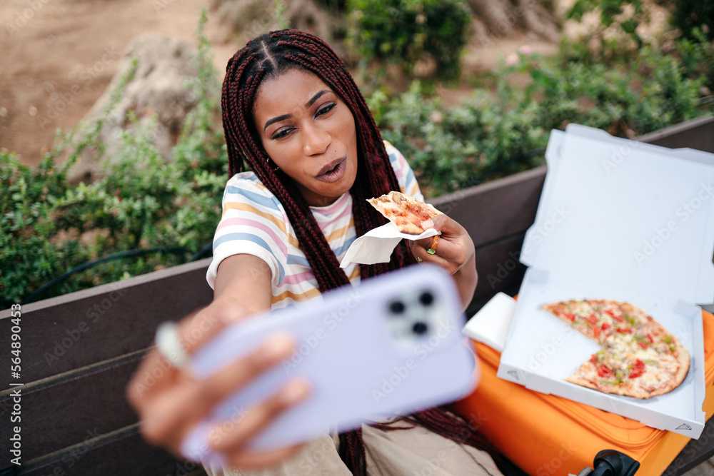 Gen Z black woman eating pizza in the street Stock Photo | Adobe Stock