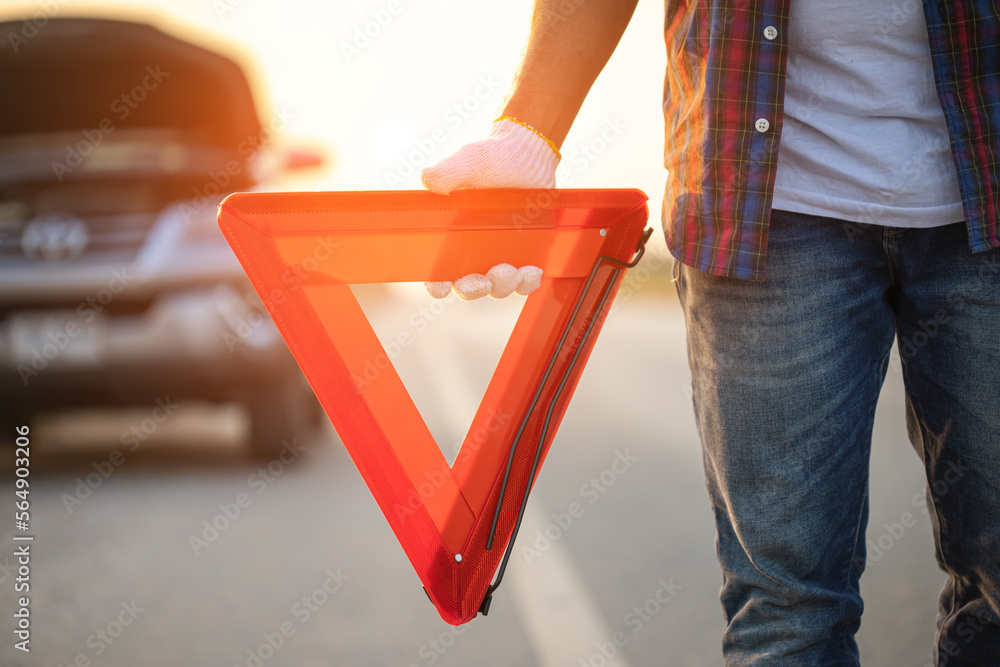 Man holding red emergency stop sign and put on the roadside. Car ...