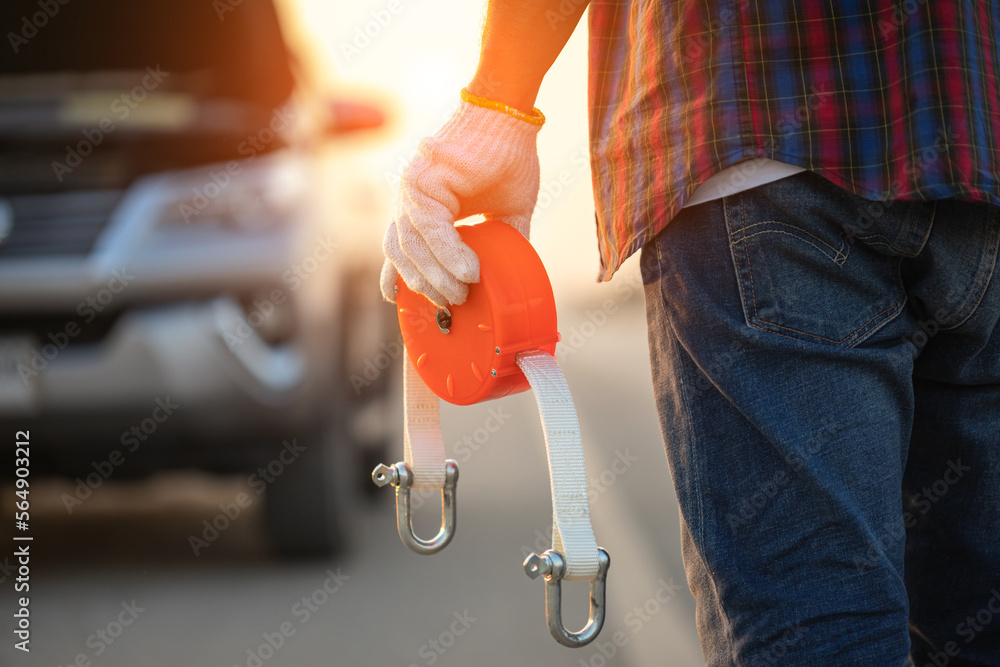 Man holding emergency car towing line and standing infront of car on ...