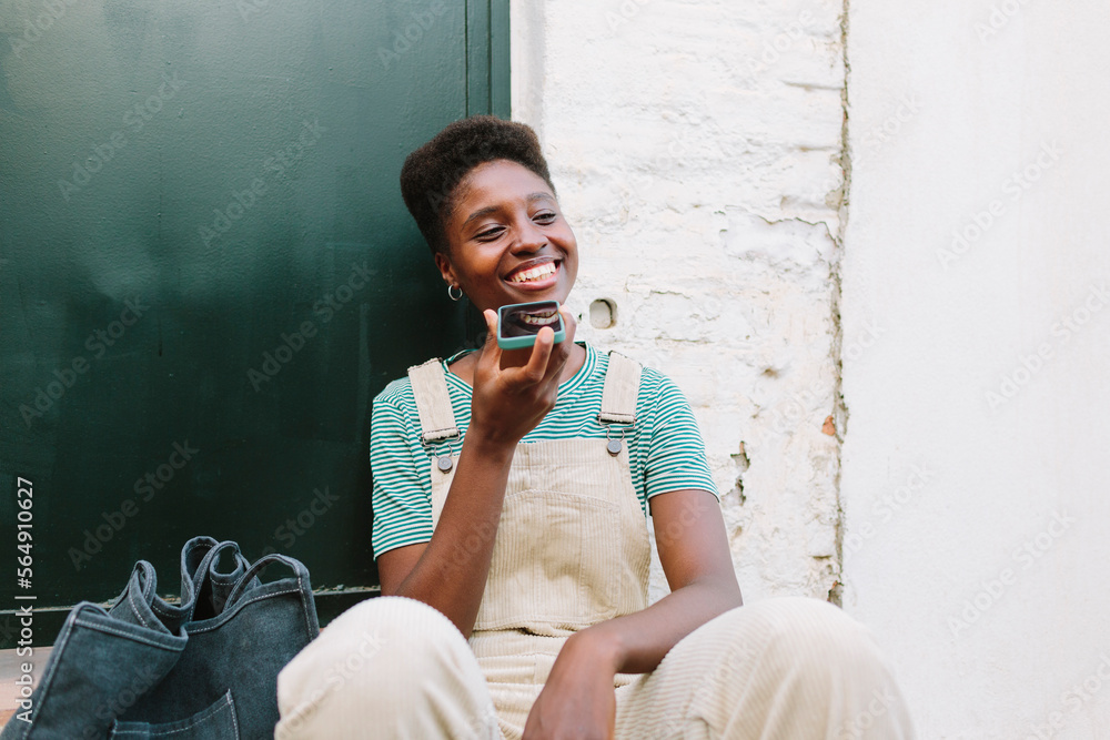 African woman recording a voice note Stock Photo | Adobe Stock