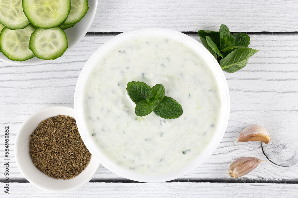 Indian raita sauce with yogurt, cucumber and herbs on a white ...