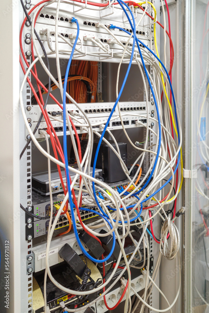 in a server rack many different colored network cables are connected to ...