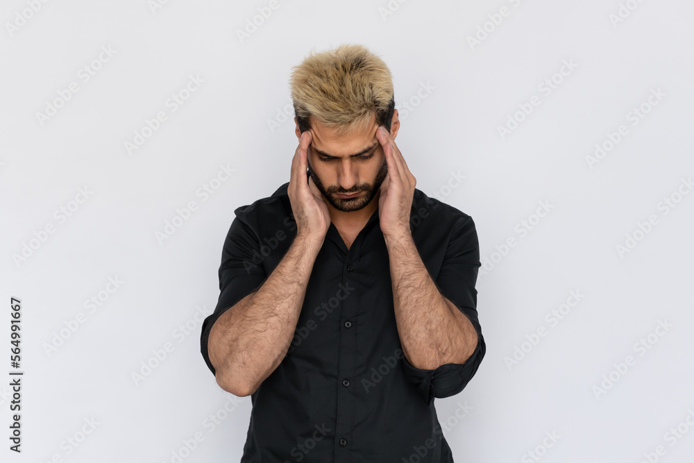 Portrait of overloaded young man rubbing head over white background ...