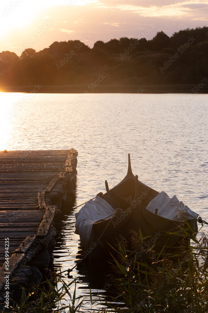 Wooden boardwalk with viking boat at the historical Hedeby harbour ...