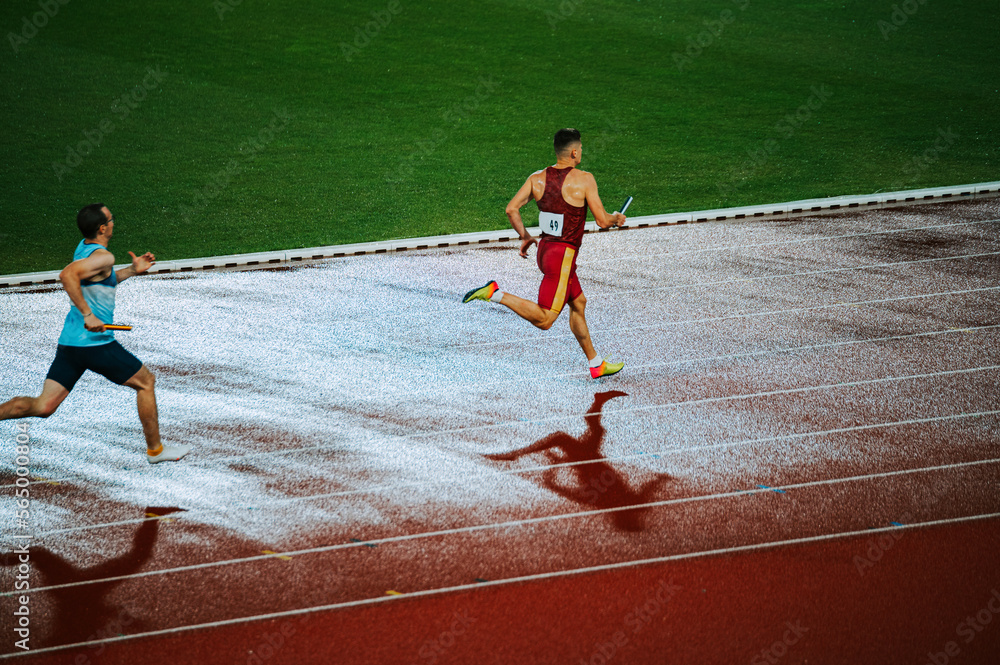 Alone sprinter captured in motion on the athletics track in rainy ...