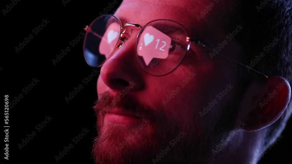 Growth of social media popularity. Likes. Close up view of man's eyes in glasses looking at pc ...