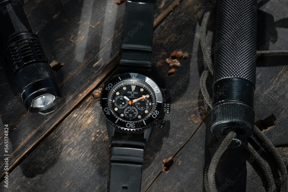 SEIKO Prospex black diver watch and knife on wooden table. Black ...