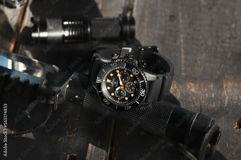 SEIKO Prospex black diver watch and knife on wooden table. Black ...