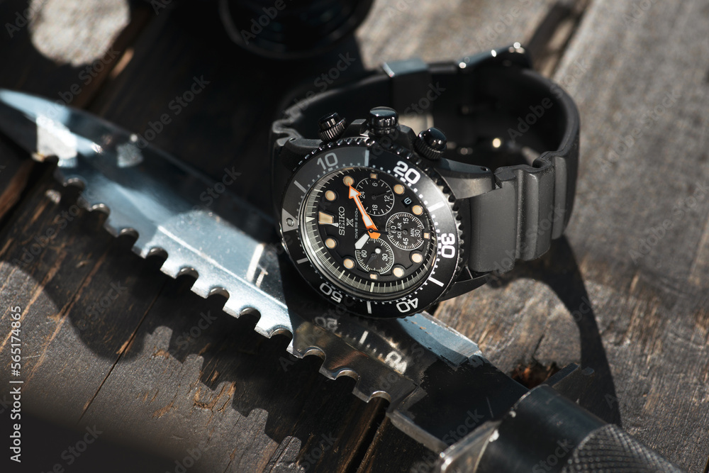 SEIKO Prospex black diver watch and knife on wooden table. Black ...
