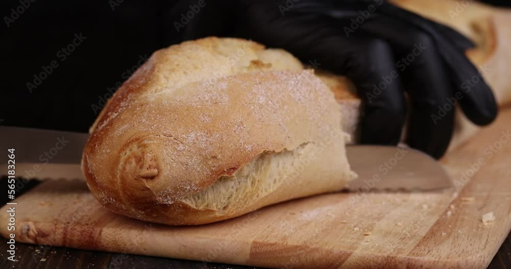 Slicing soft fresh bread while cooking, a loaf of soft bread while ...