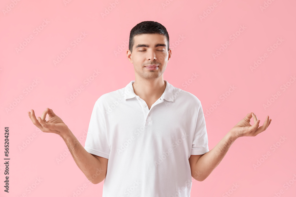 Young guy meditating on pink background Stock Photo | Adobe Stock