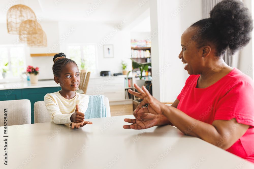 Happy african american grandmother and deaf granddaughter using sign ...