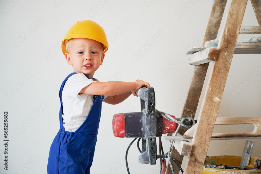 Adorable little boy construction worker holding electric power drill ...