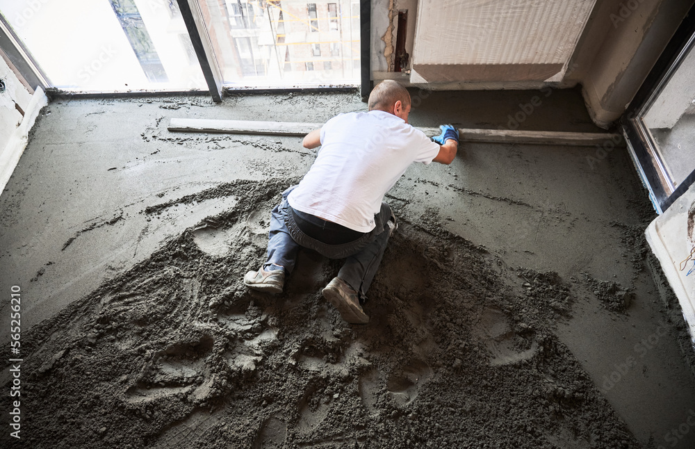 Top view of male construction worker using screed rail while screeding ...