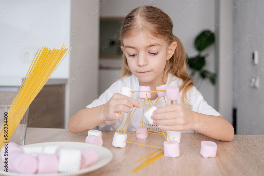 Little girl having fun time learning molecular structure. Concentrated ...