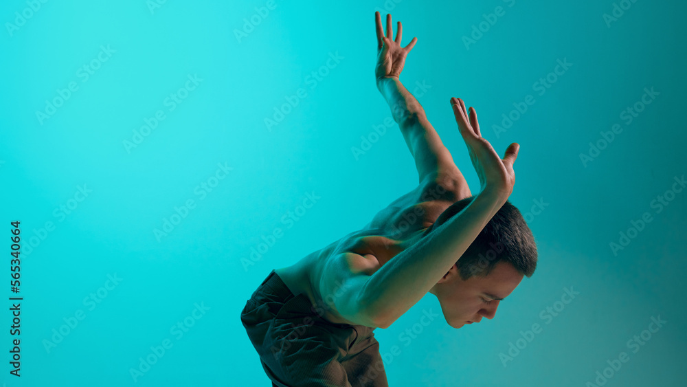 Contemporary dance style. Young shirtless man dancing over blue cyan ...