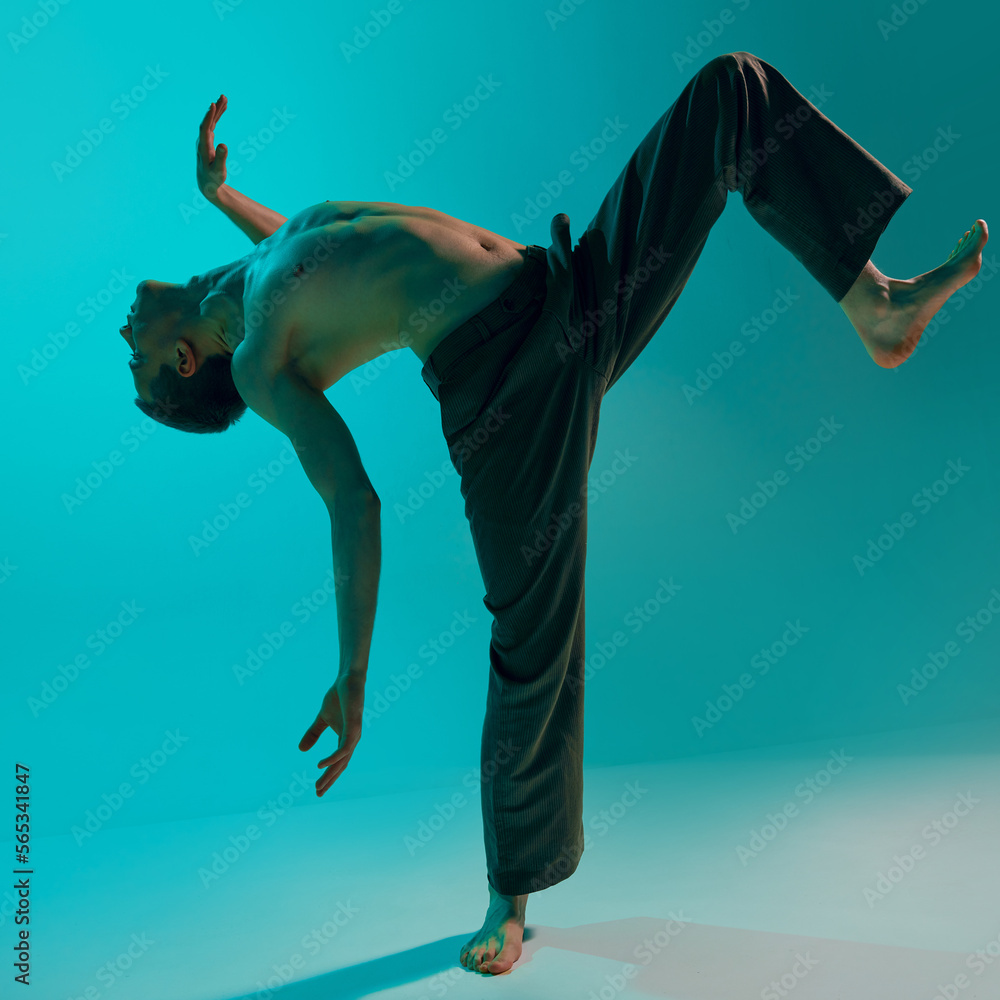 Contemporary, modern dance style. Young flexible shirtless man dancing ...