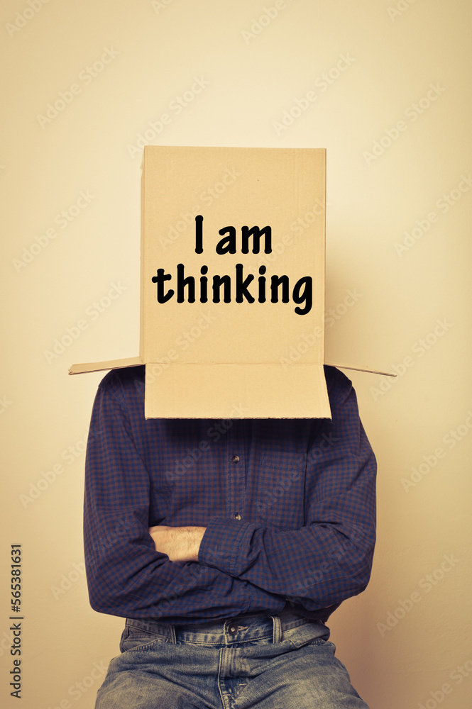 man sitting with a cardboard box over his head, I am thinking concept ...