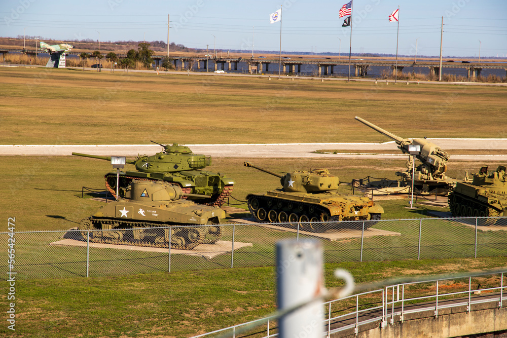 Green military tanks and guns surrounded by lush green grass, trees ...