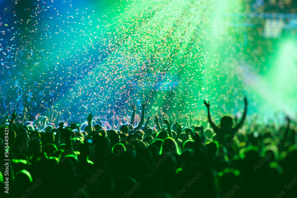 A crowded concert hall with scene stage green lights, rock show ...