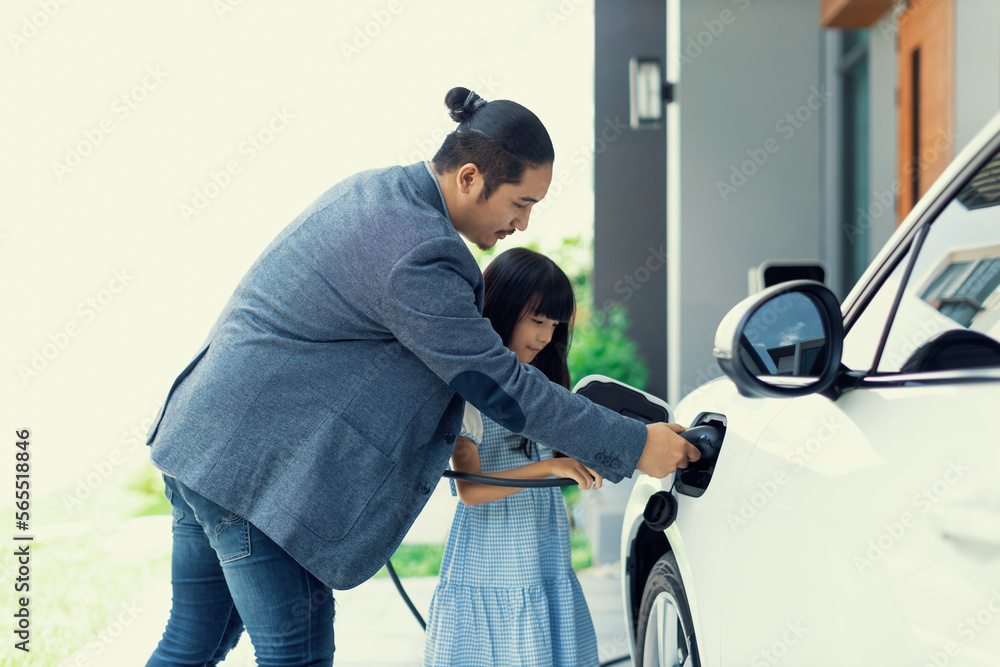 Progressive father and daughter plugs EV charger from home charging ...