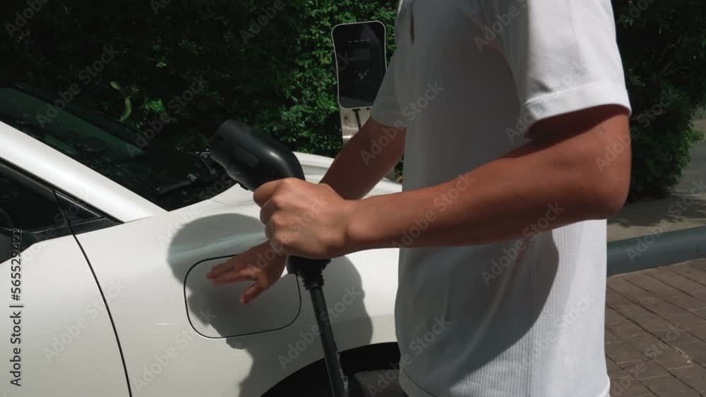 Progressive man install power cable plug to his electric vehicle, EV ...