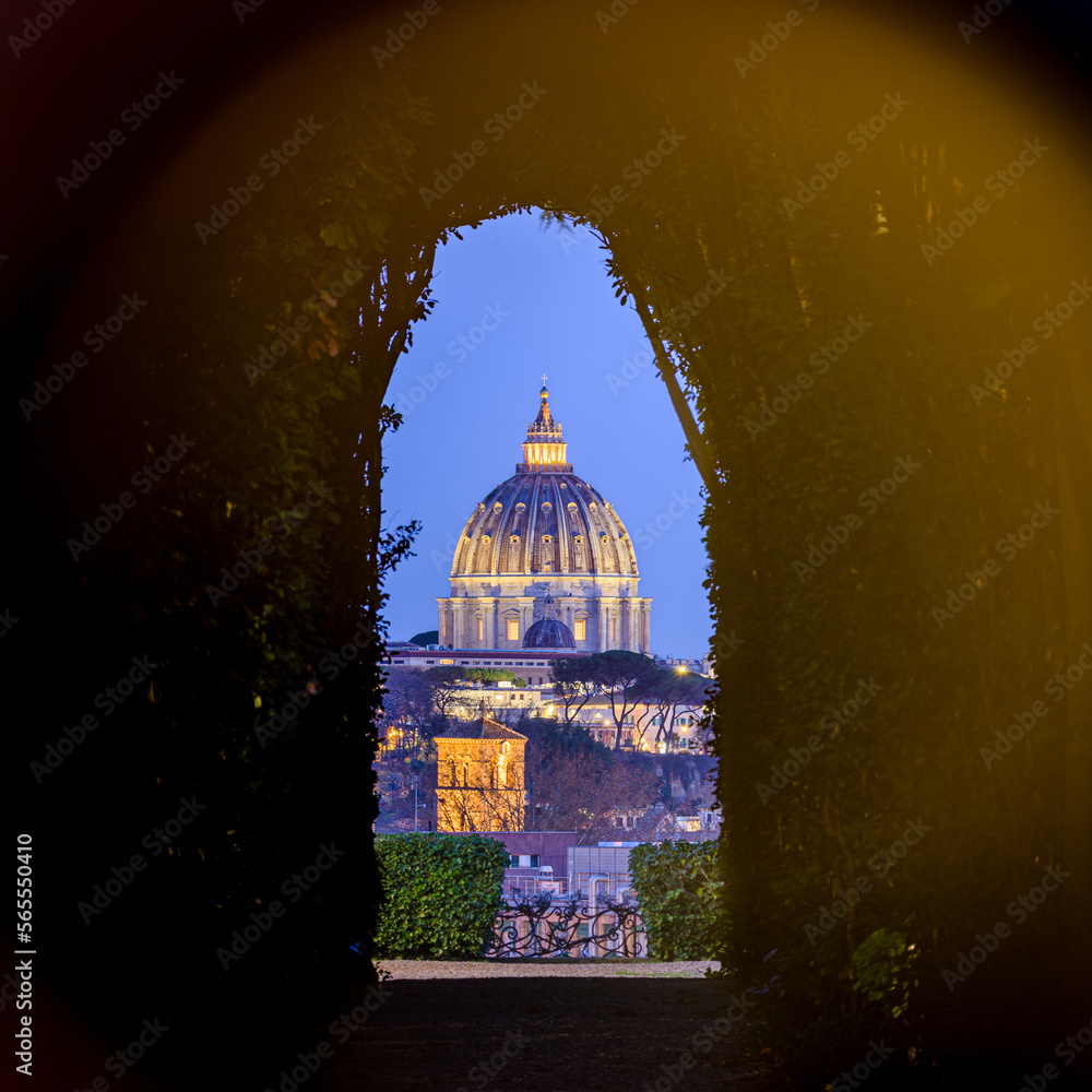 View of the Vaticana and St Peter basilica through a tree line and a door keyhole, a famous ...