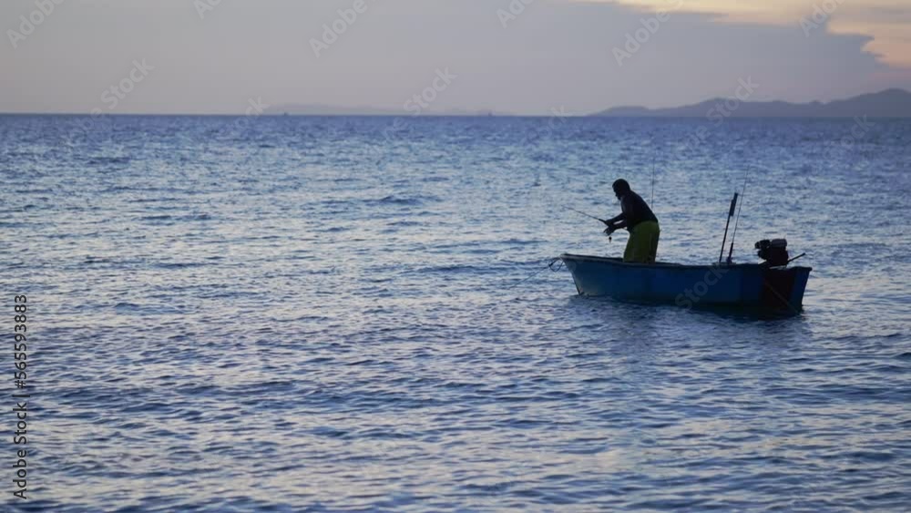 Man fishing on sea water in a boat at sunset, Fisherman try to catch ...