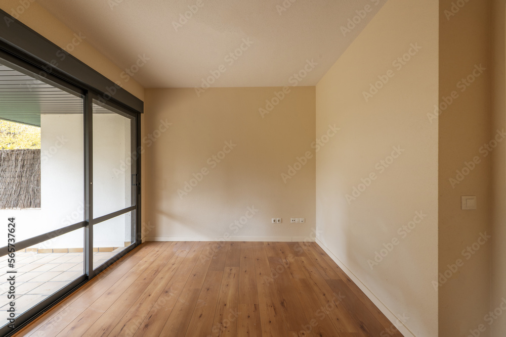 Small empty room with brown wooden flooring with cream walls and a ...