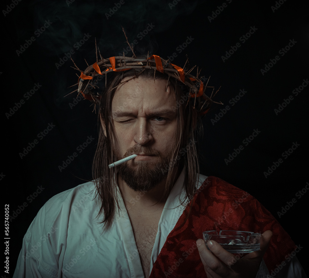 Fotografia do Stock: Jesus Christ smokes a cigarette wearing a crown of ...