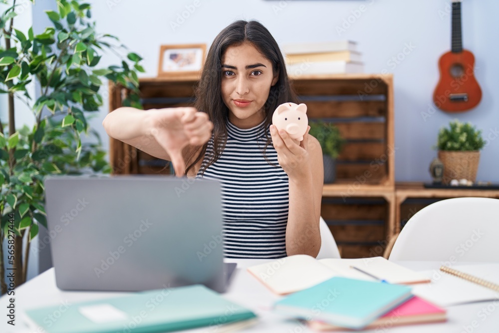 Young teenager girl studying using computer laptop with angry face ...